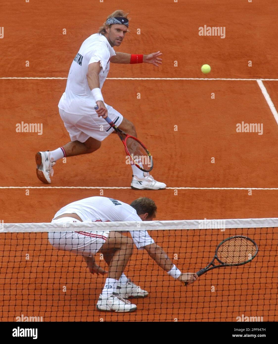 Argentine David Nalbandian, falls as he teammate Lucas Arnold, returns ...
