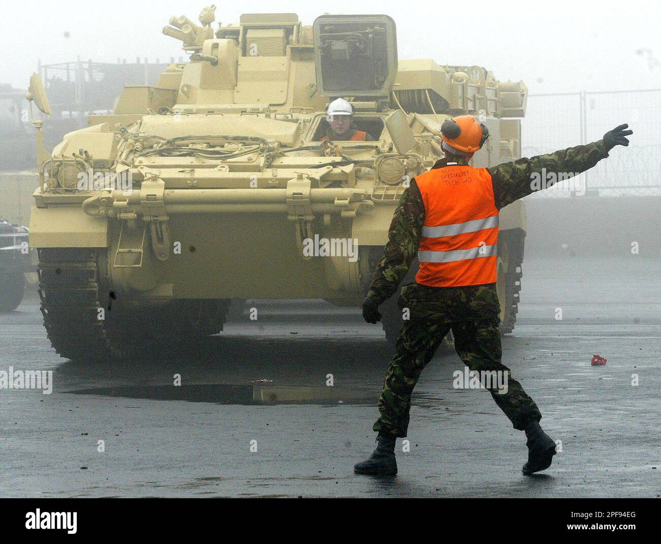 A British soldier directs an armoured vehicle through the fog during ...