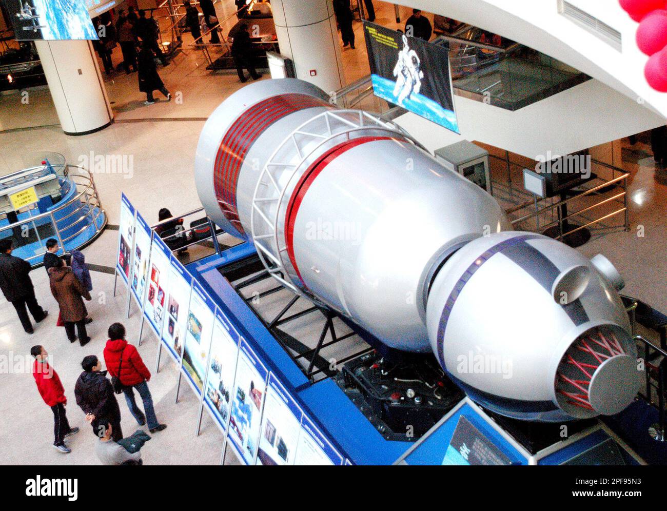 Visitors look at a model of a spacecraft at Beijing's Science and ...