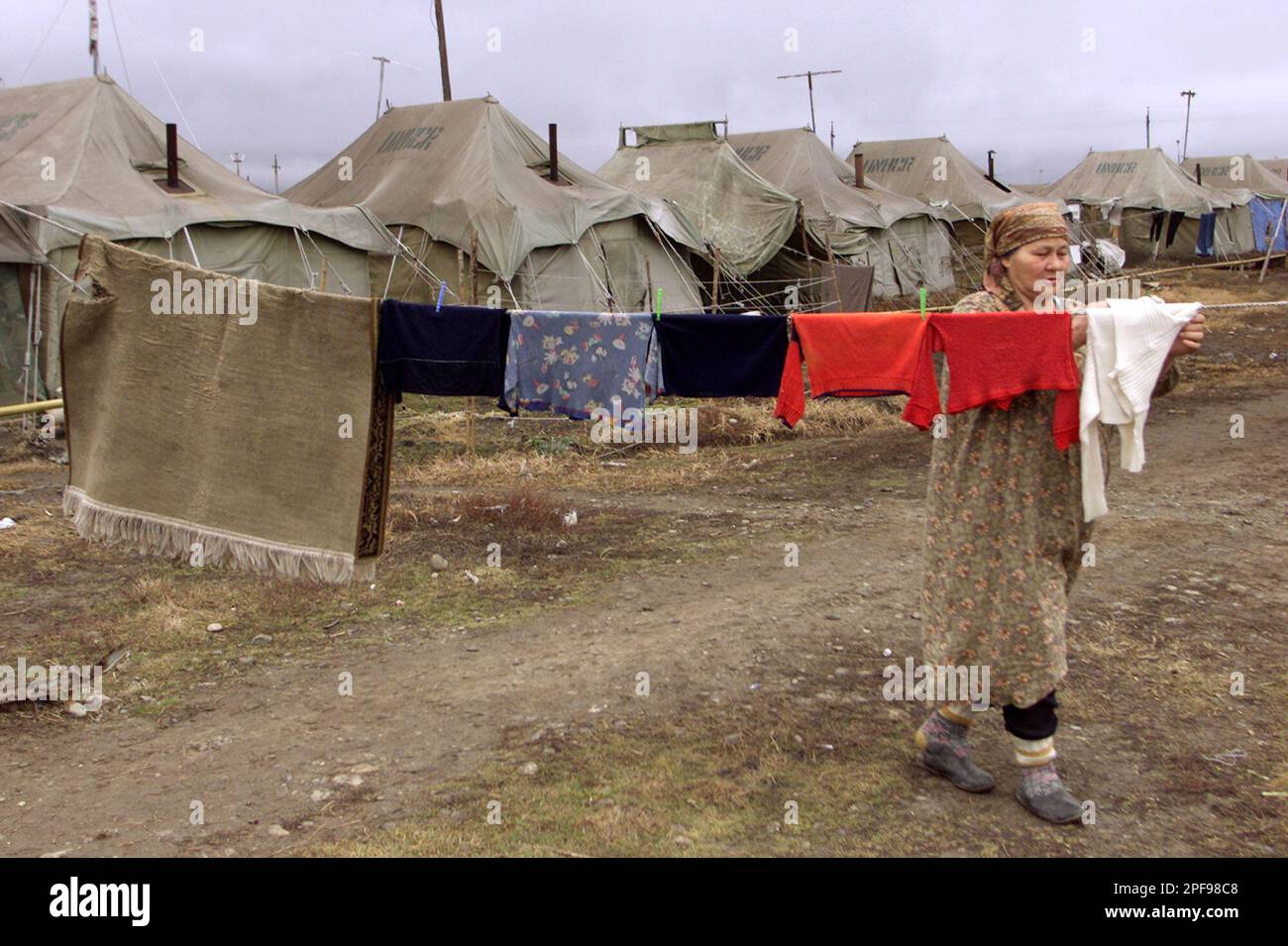 A Chechen refugee woman dryes clothes at the Sputnik refugee camp, just ...