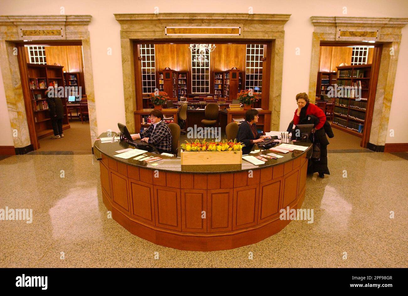 A library patron visits the reference desk at the newly renovated ...