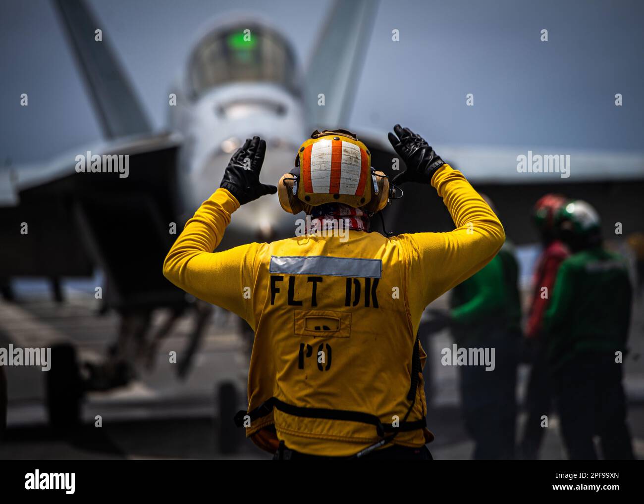 230316-N-MH015-1093 PHILIPPINE SEA (March 16, 2023) A U.S. Navy Sailor directs an F/A-18E Super ...
