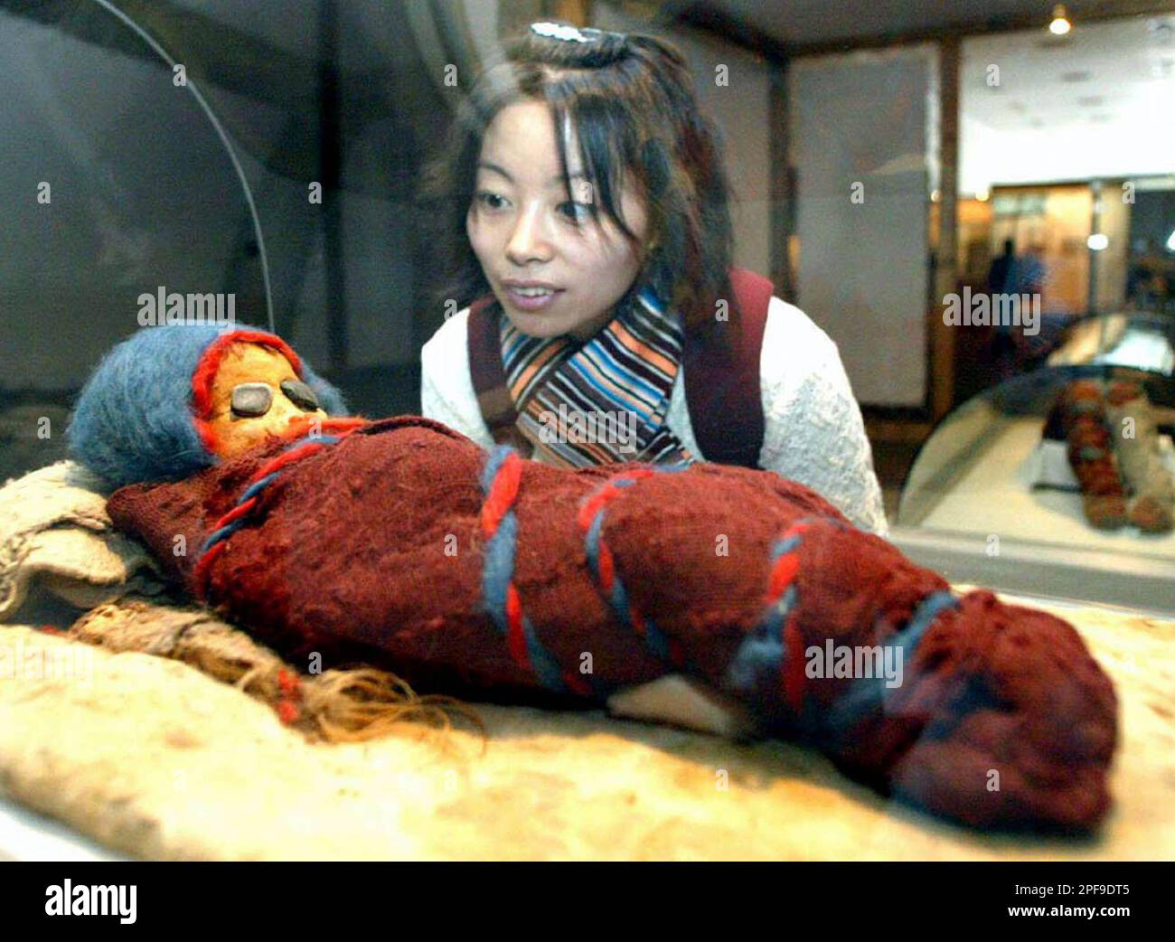 A Chinese visitor exmaines a mummified baby from 800 BC discovered in ...
