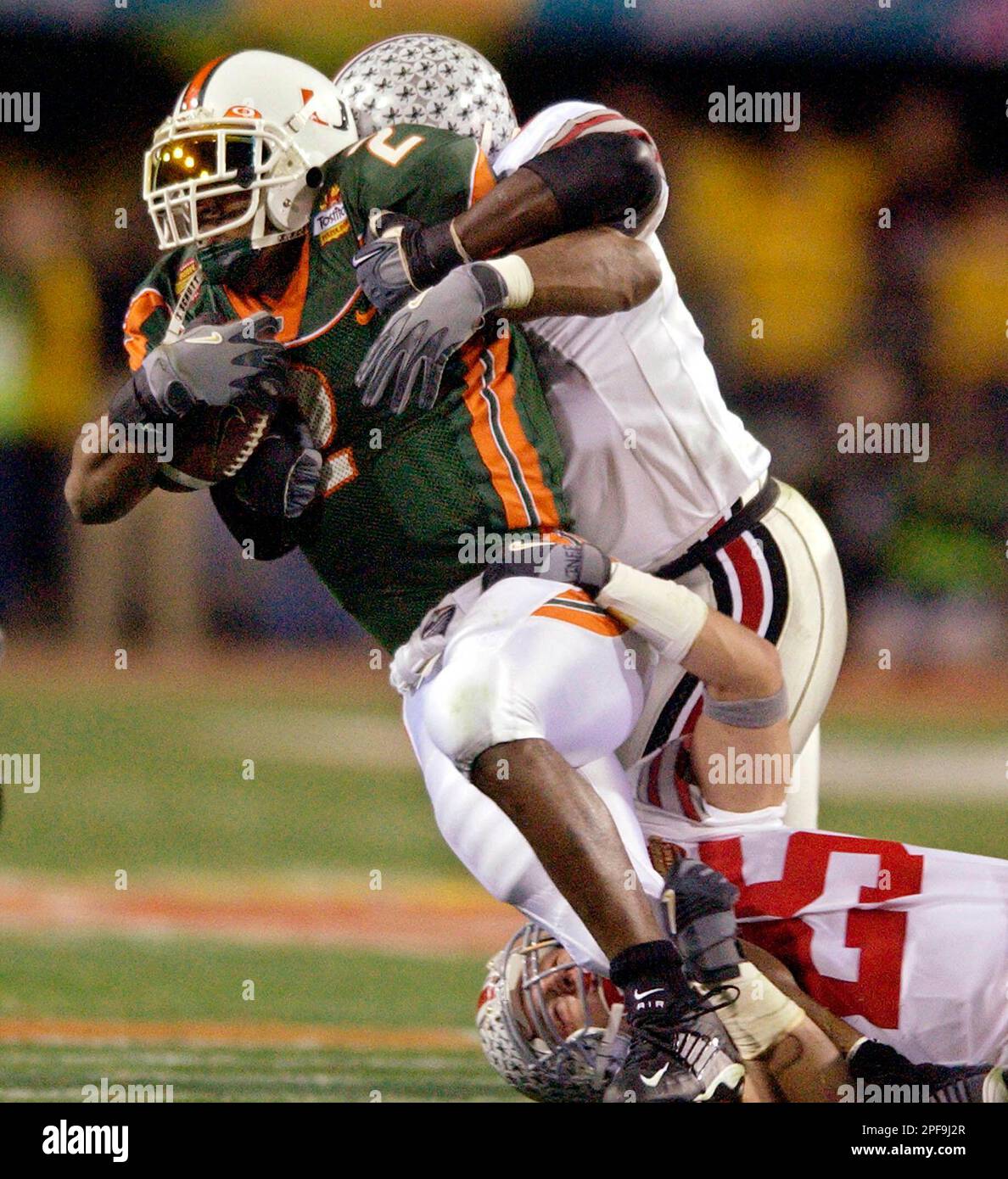 Miami's Willis McGahee, left, is pulled down by Ohio State's Cie Grant ...