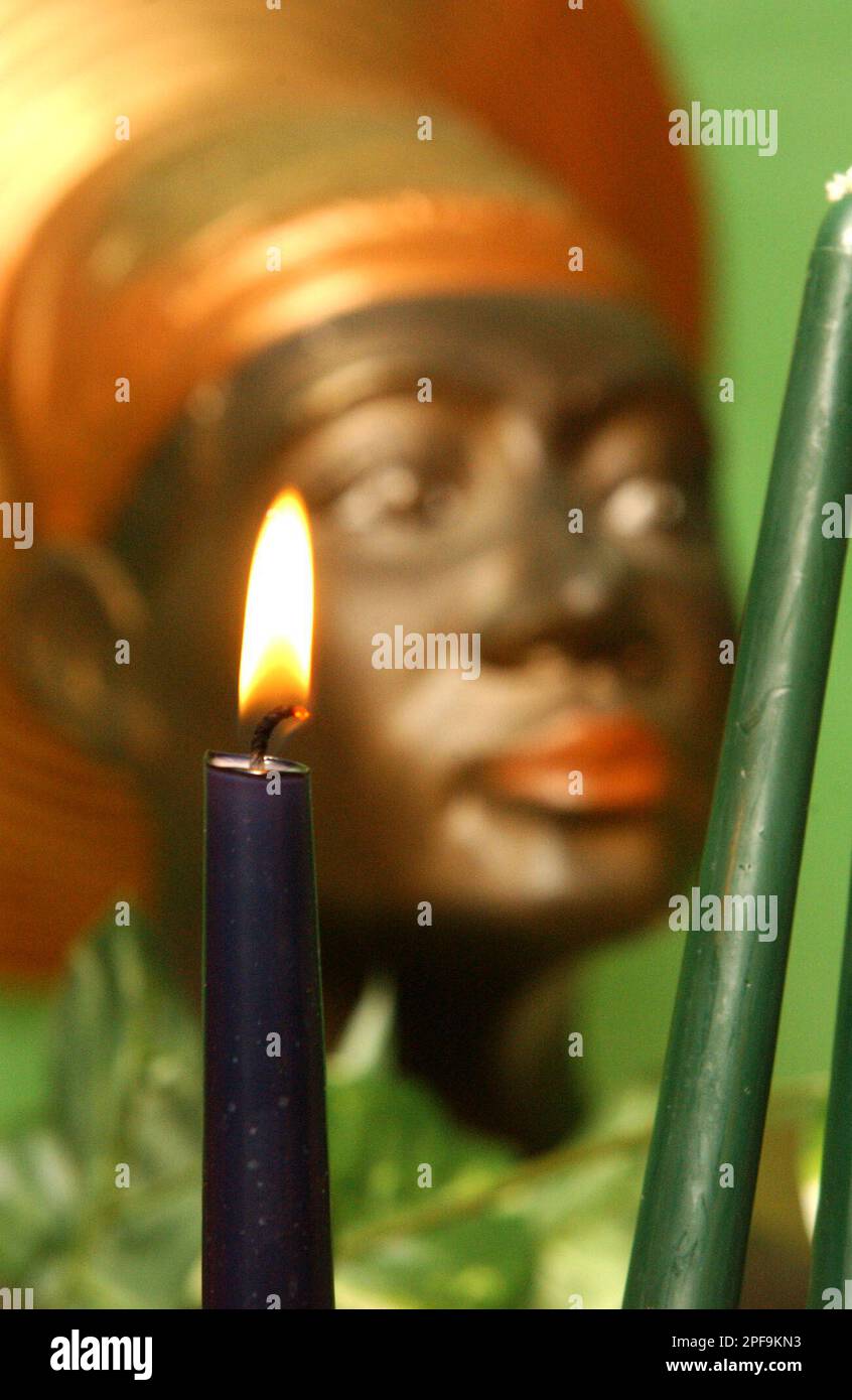 The first candle of Kwanzaa, for unity, is lit at the Emmit Scott ...