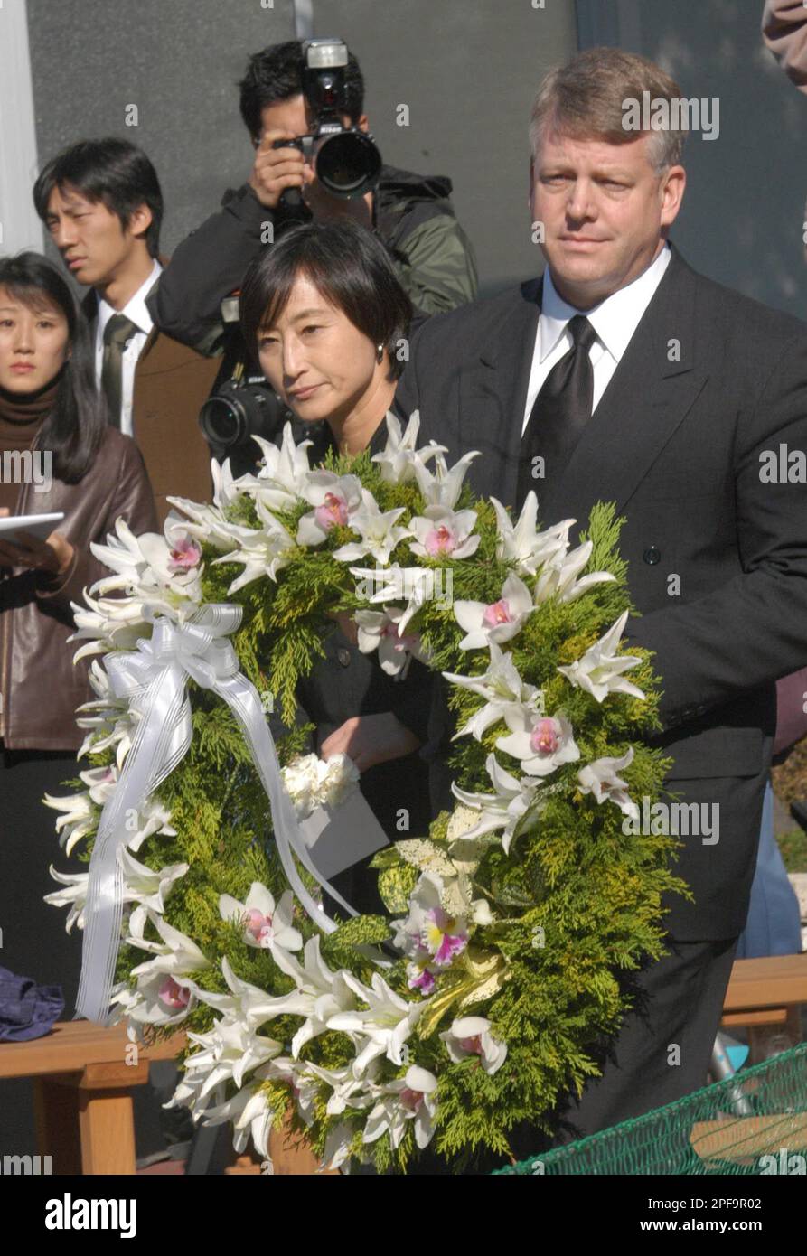 Retired U.S. Navy Cmdr. Scott Waddle, right, walks with a wreath to the ...