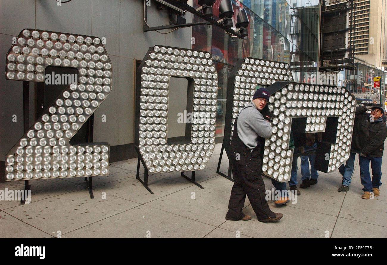 Employees of the Landmark Sign Company carry the 3 from the Times ...