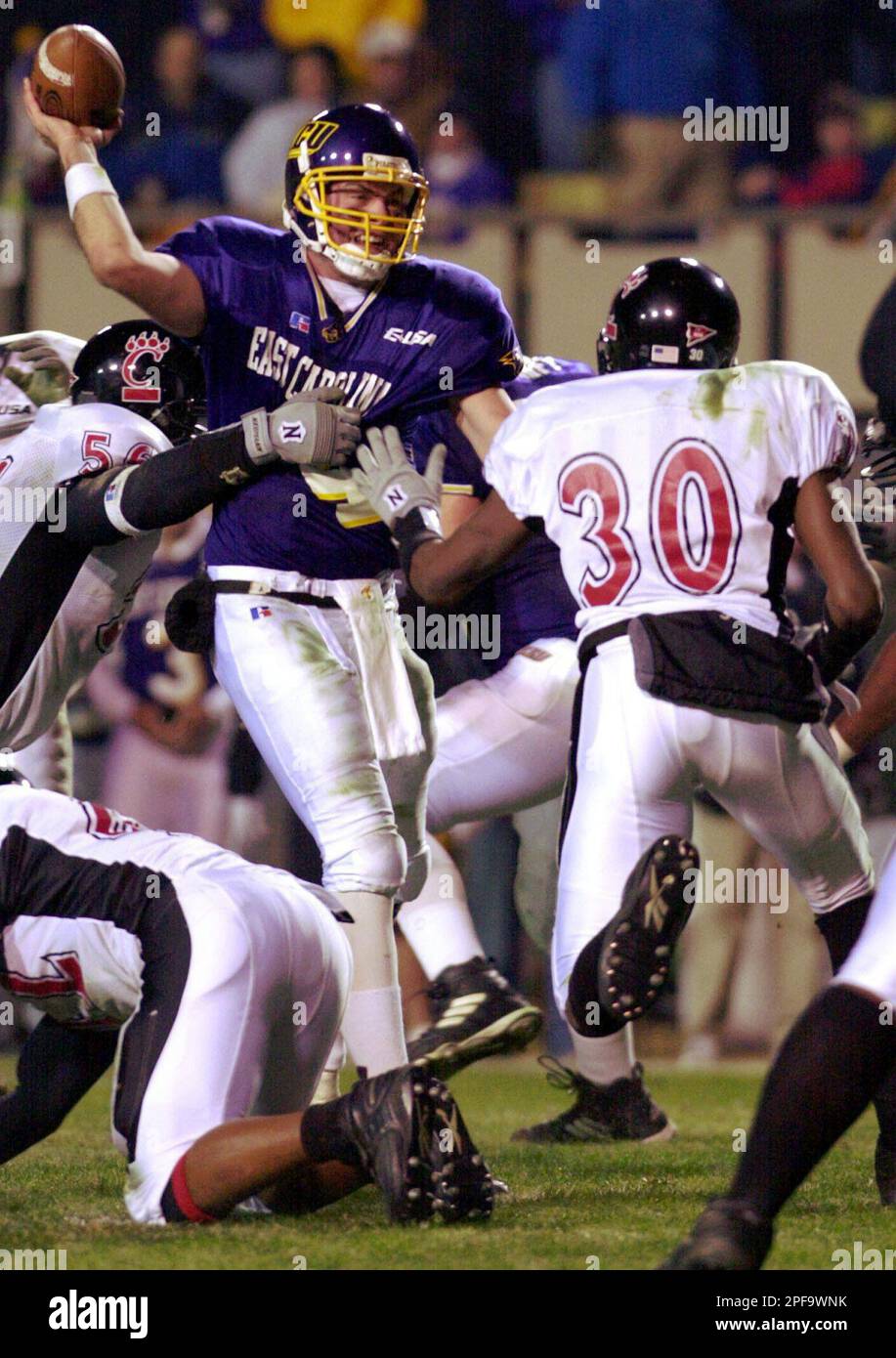 East Carolina quarterback Paul Troth, center, is stopped by Cincinnati ...