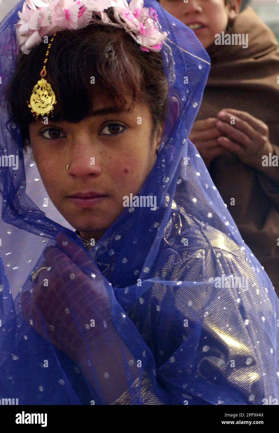 A girl wearing new clothes for the Eid day, walks in the streets of Kandahar, Afghanistan ...
