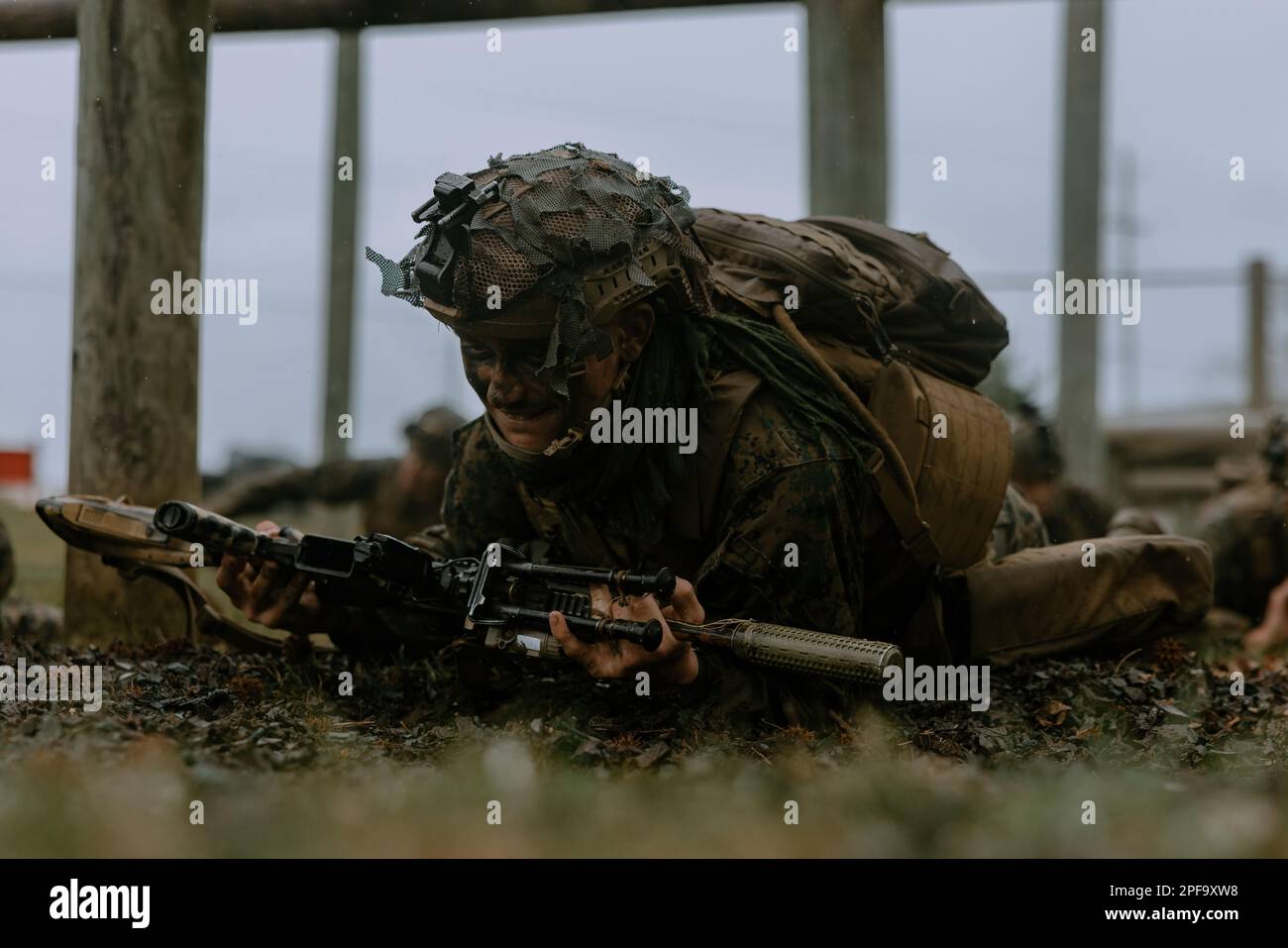A U.S. Marine with 2d Marine Division (MARDIV) low crawls through an ...