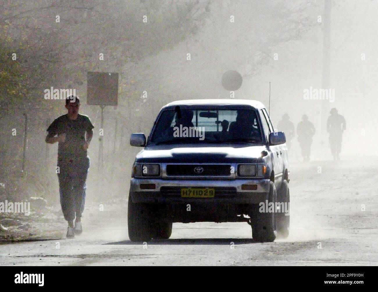 Soldiers endure the dust as they jog around the base to keep themselves ...