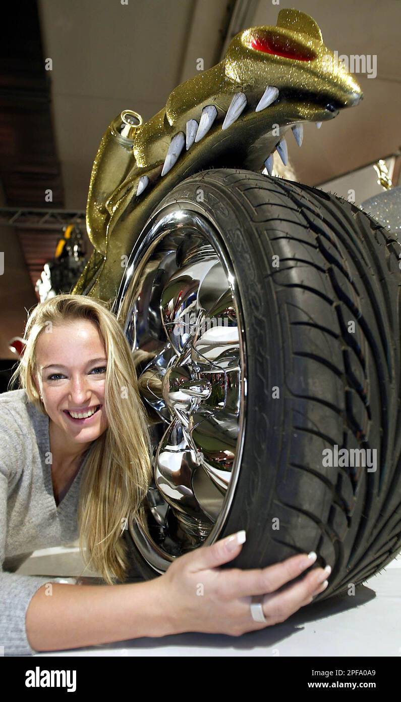 Model Xenia posiert am Vorderrad des Crazy-Car Gothic Coach mit Design ...