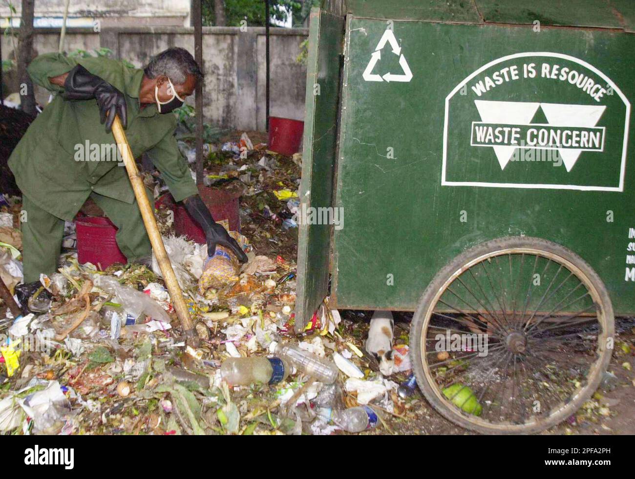A Waste Concern worker collects garbage at a processing center in ...