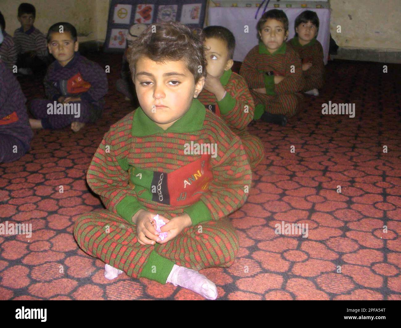 Afghan orphans sit on the floor at an orphanage outside the Afghan ...