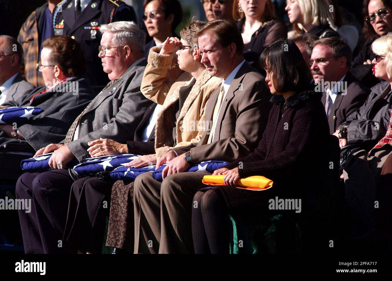 Family members holds flags that draped the casket of the remains of ...