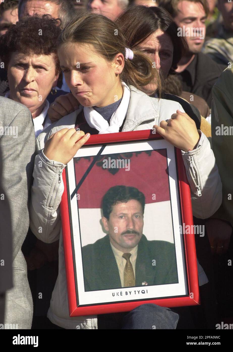 Shqipe Bytyci weeps while holding the picture of her father Uke Bytyci ...