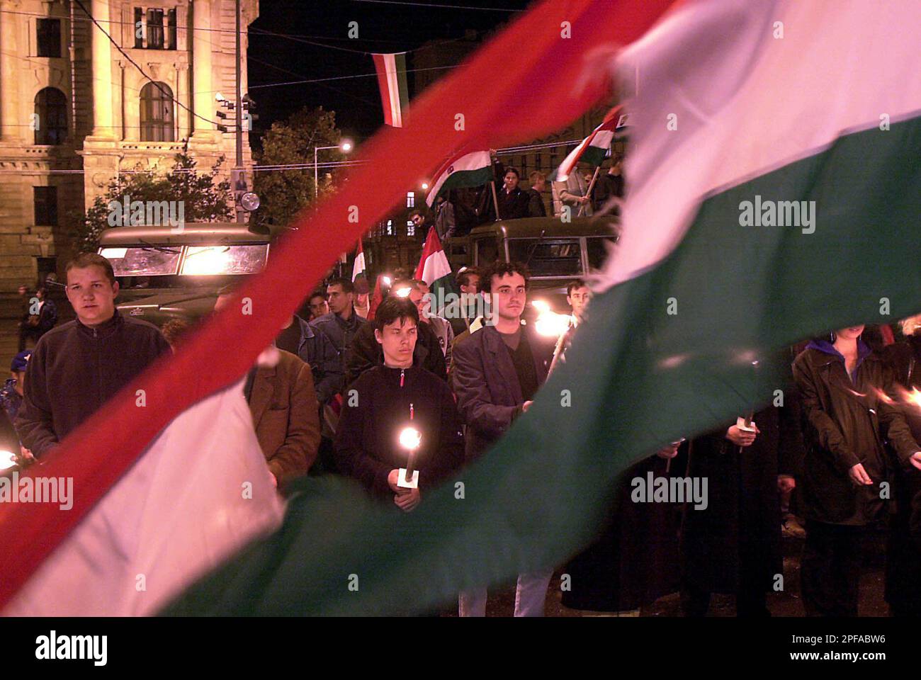 People stand with torches and national flags in their hands as they ...