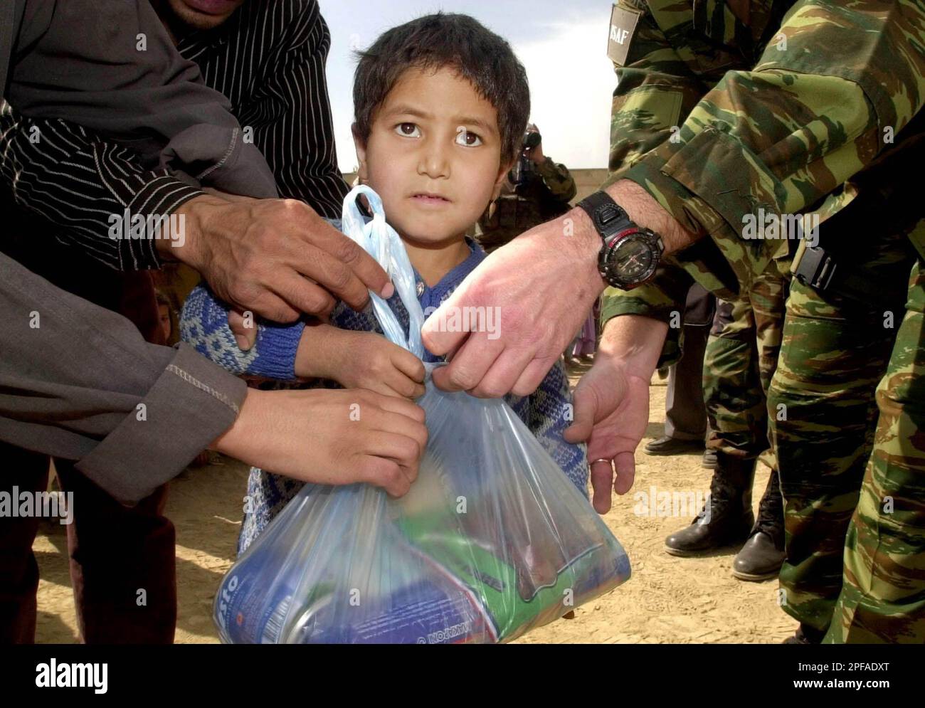 A boy carries a bag of food given to him by the Greek contingent of the ...