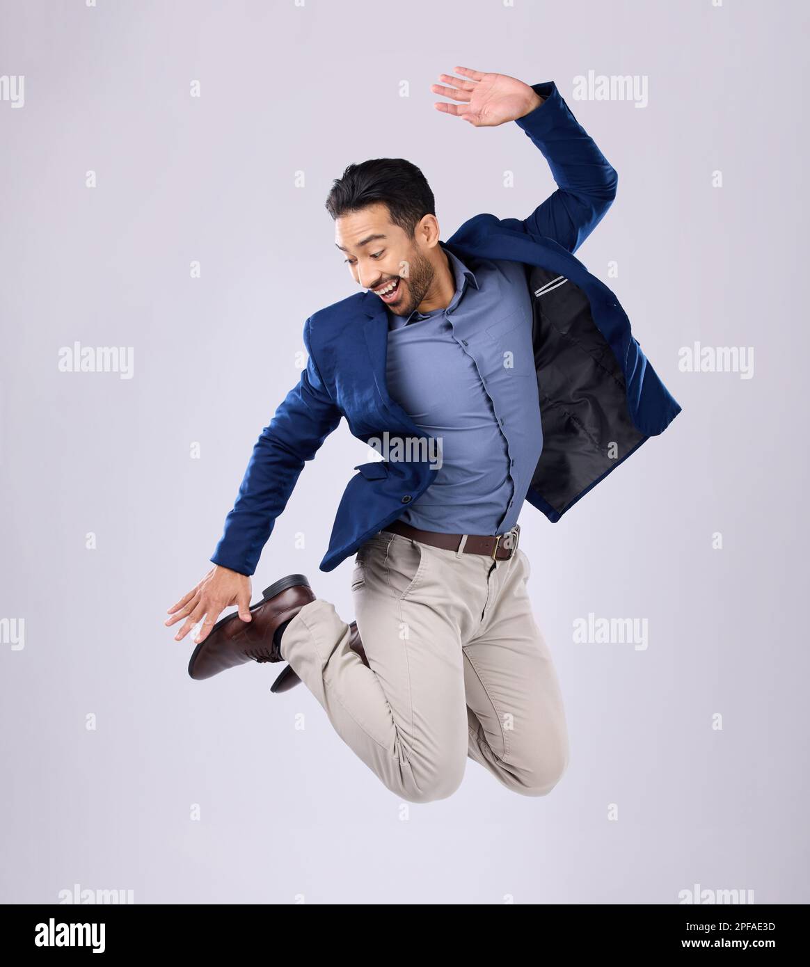 Businessman, excited and jumping in studio with happy smile with ...