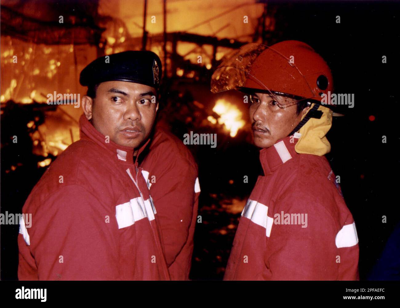 Rescue workers pause in front of the blaze ignited by a bomb blast at ...