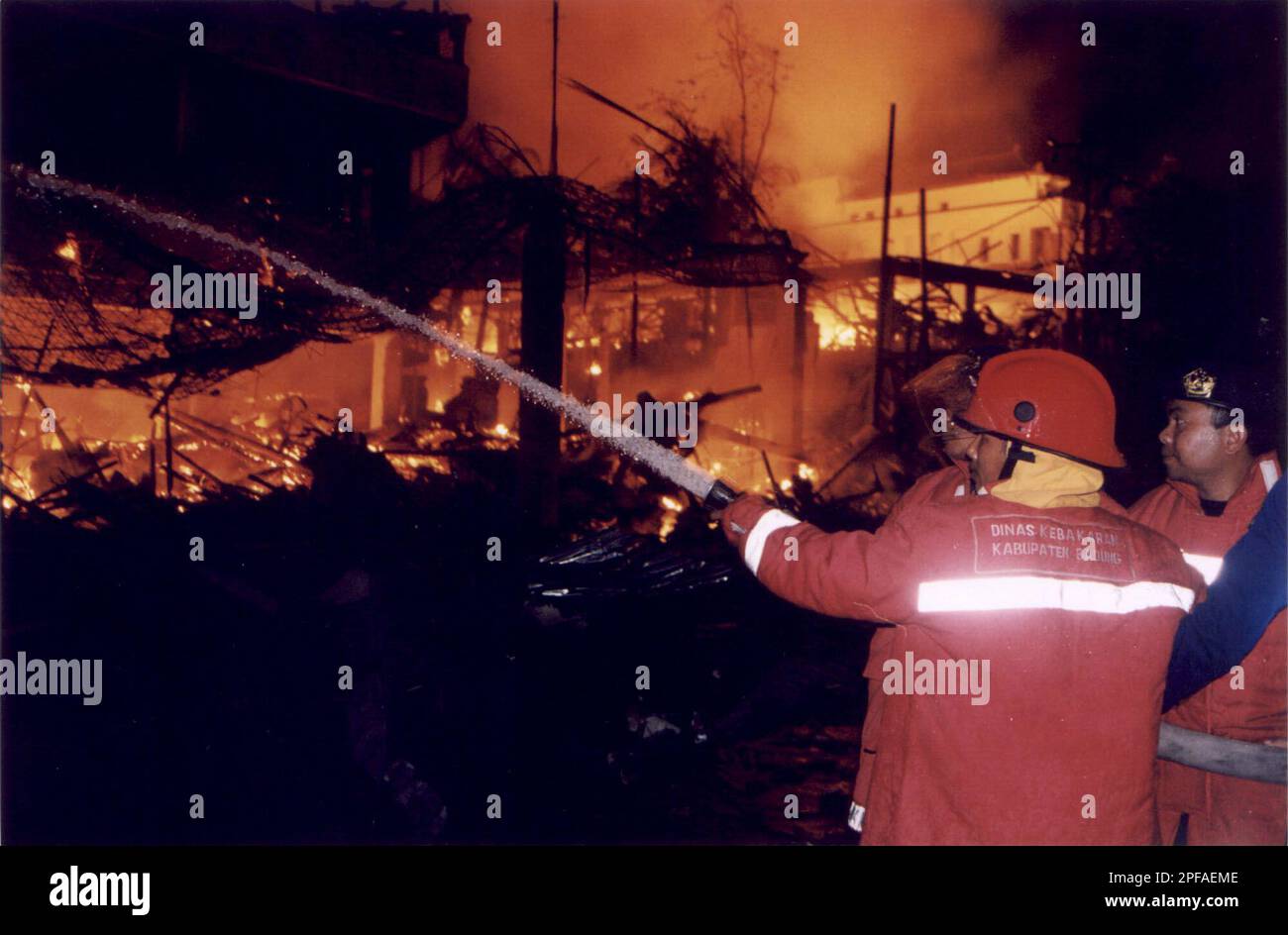 Fire fighters attempt to extinguish the blaze ignited by a bomb blast ...