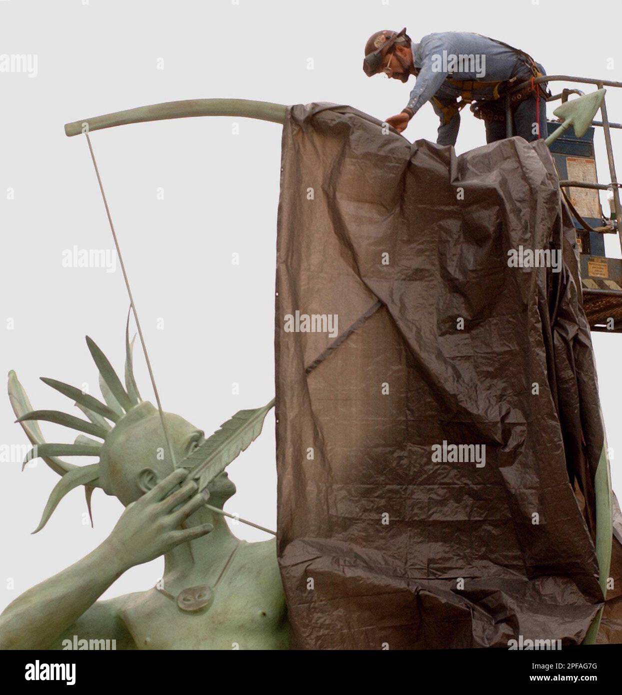 Workers load the statue, called "Ad Astra," on a flat bed truck ...