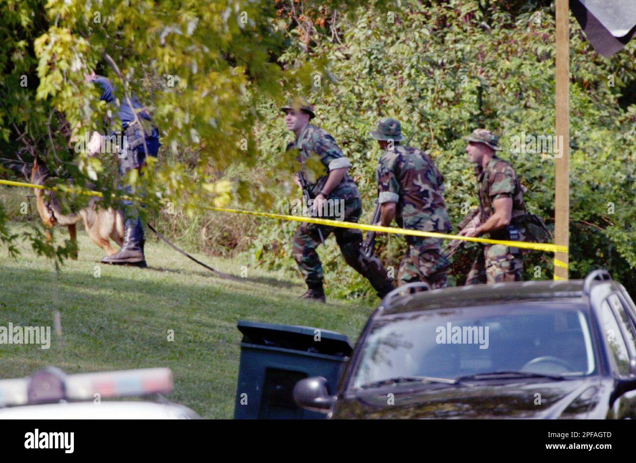A heavily-armed tactical team walks into the woods around the Benjamin ...