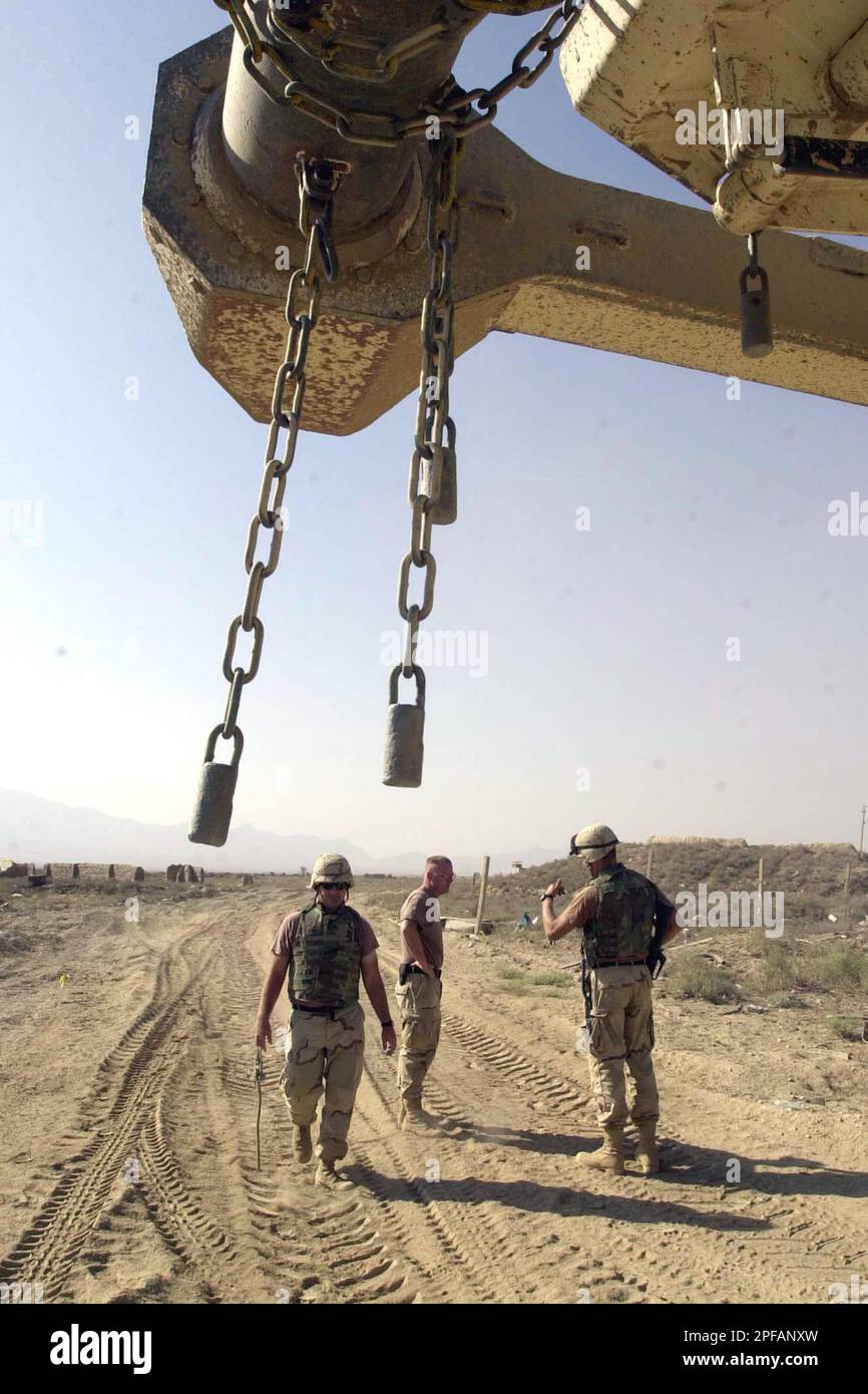 The U.S. Army demining team walks the path of their Hydrema 910 MCV ...