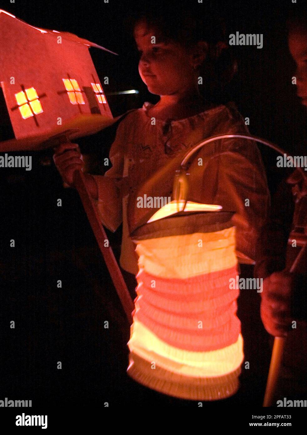 Nicole Avilla, 4, carries a lantern in the shape of a typical house ...