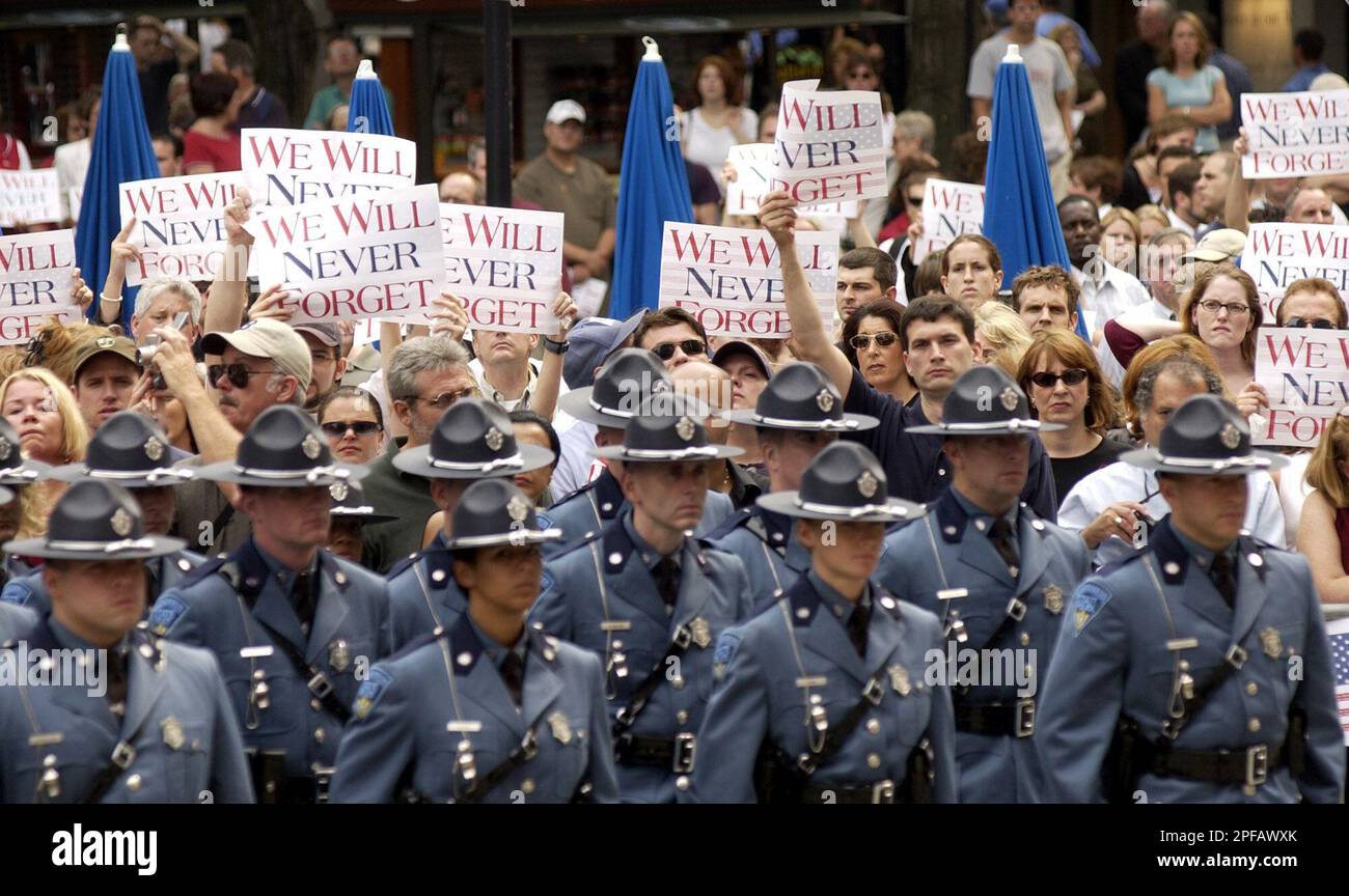 Massachusetts State Police stand at attention while people hold up ...