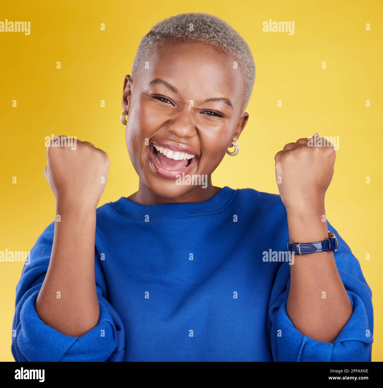 Portrait, happy black woman and fist of winner in studio for ...