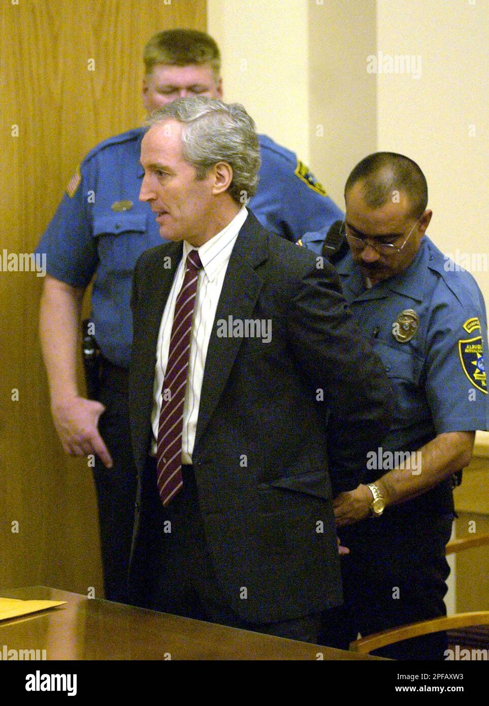 Douglas Vick Frawley, center, has his handcuffs removed by corrections ...