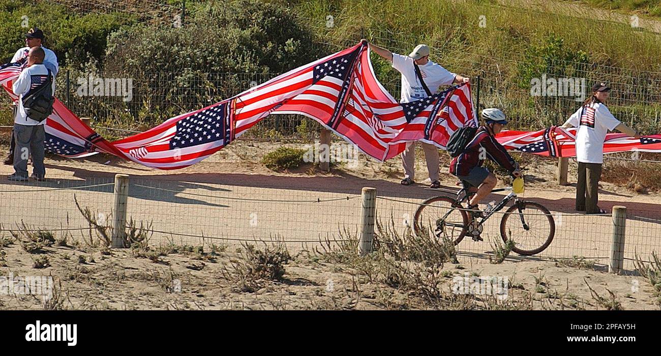 Volunteers help to hold sections of a continous 5-mile-long American ...