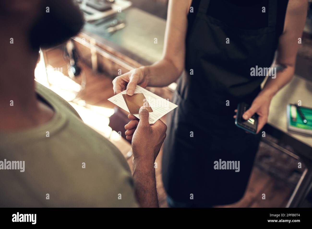 Theres your receipt and card. an unrecognisable hairdresser giving a ...