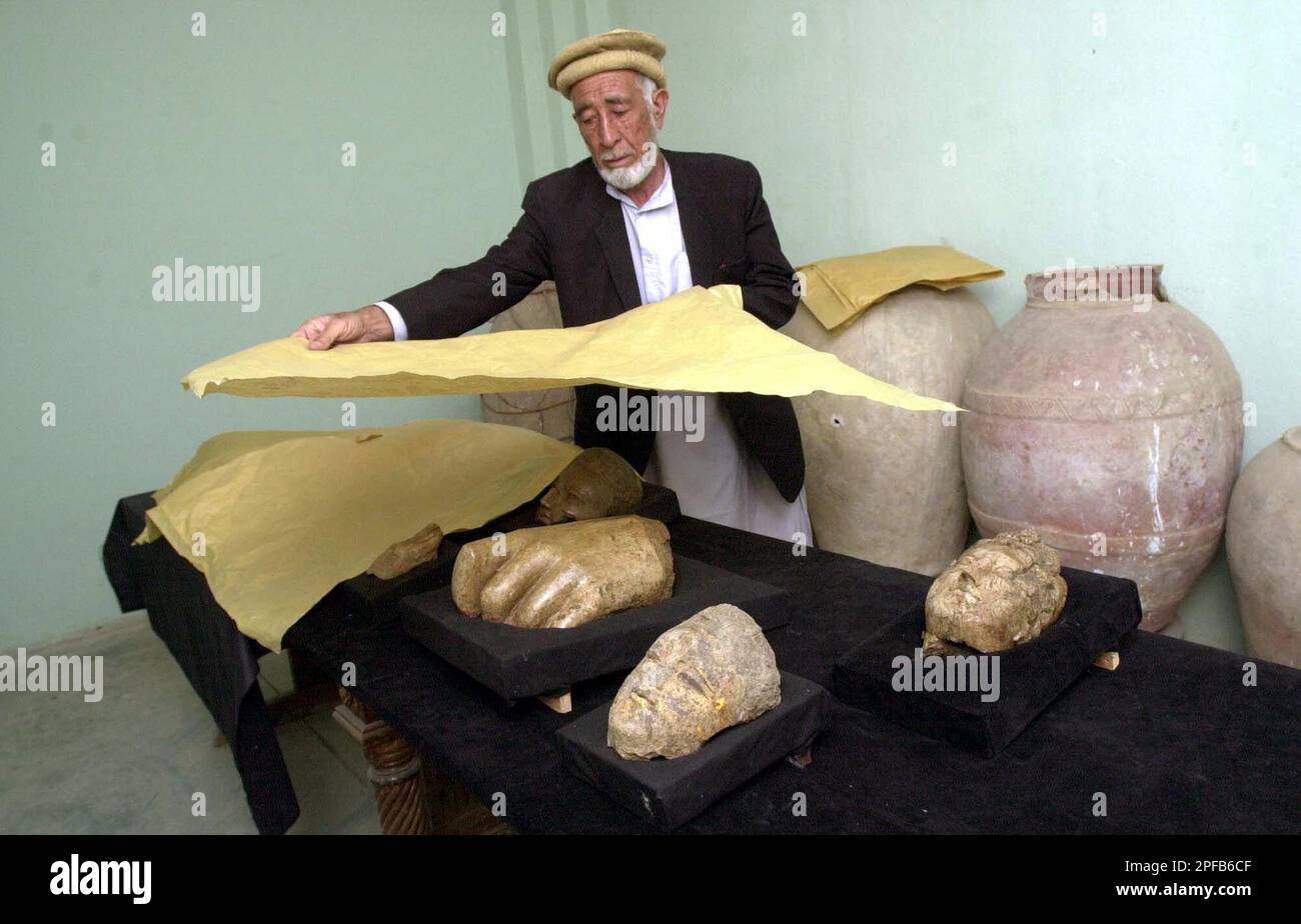 Kabul National Museum member Mir Gholam Nabi, covers some parts of ...