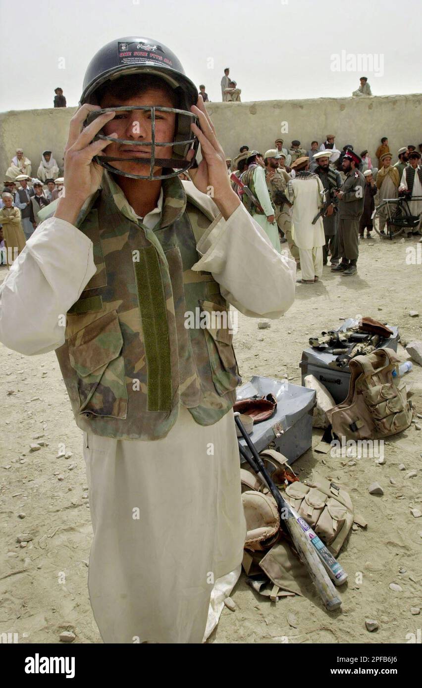 Afghan catcher Habib Rachmon of the Afghan Club, puts on his helmet and ...