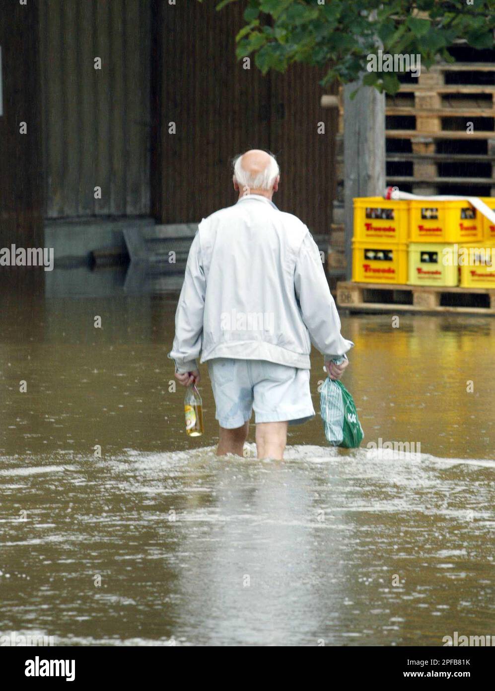 Ein Anwohner laeuft am Montag, 12. Aug. 2002, ueber sein ueberflutetes ...