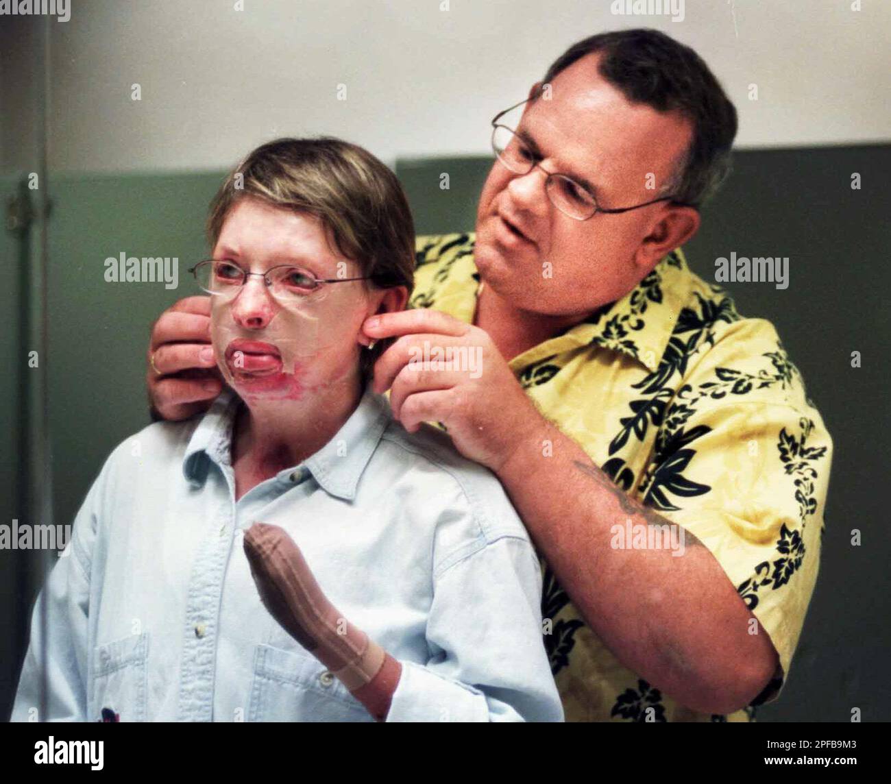 Mike Kurtz shows off the earrings that his wife, Louise, wears on her ...