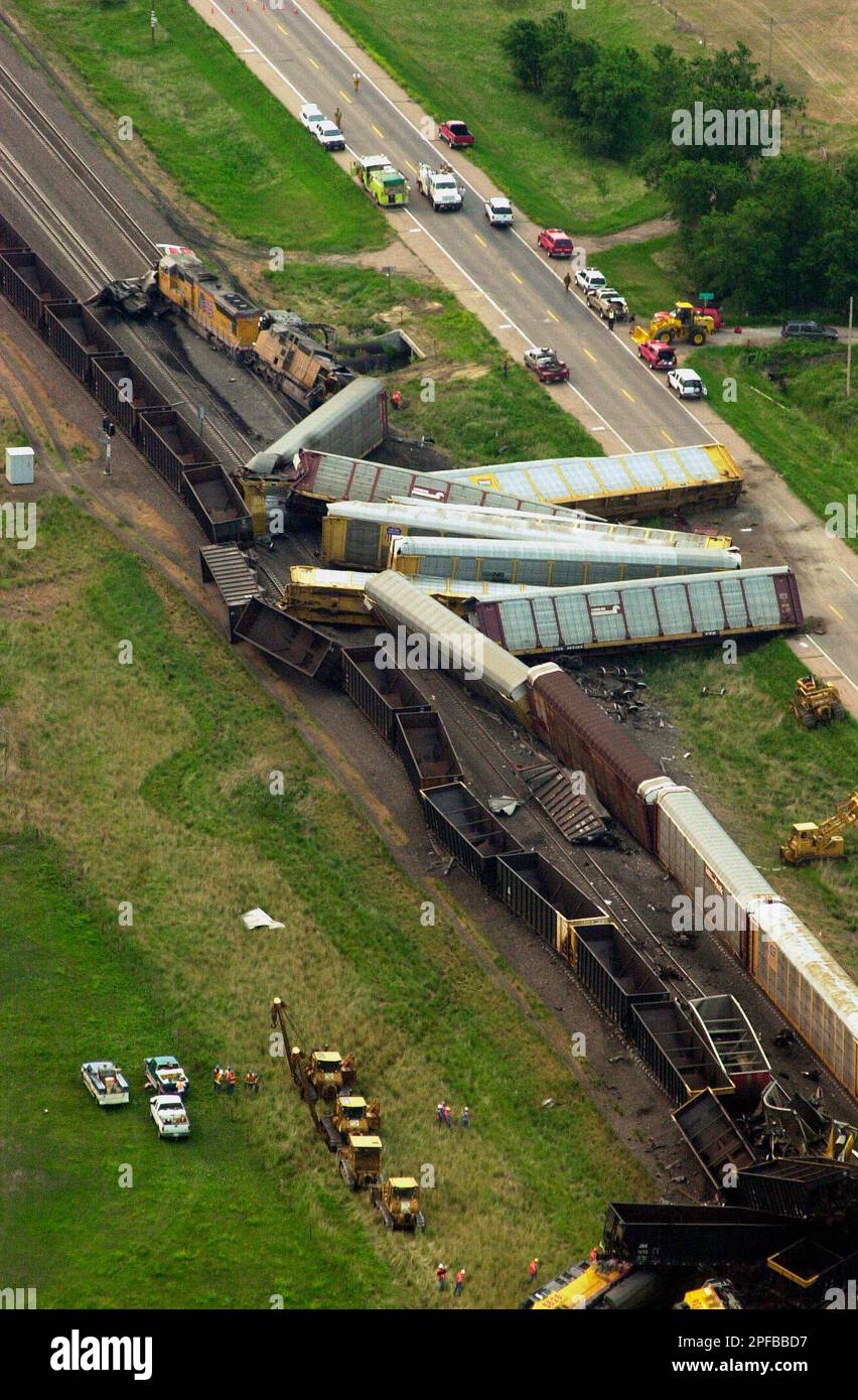 Two locomotives, one that exploded into flames, lie on their sides from ...