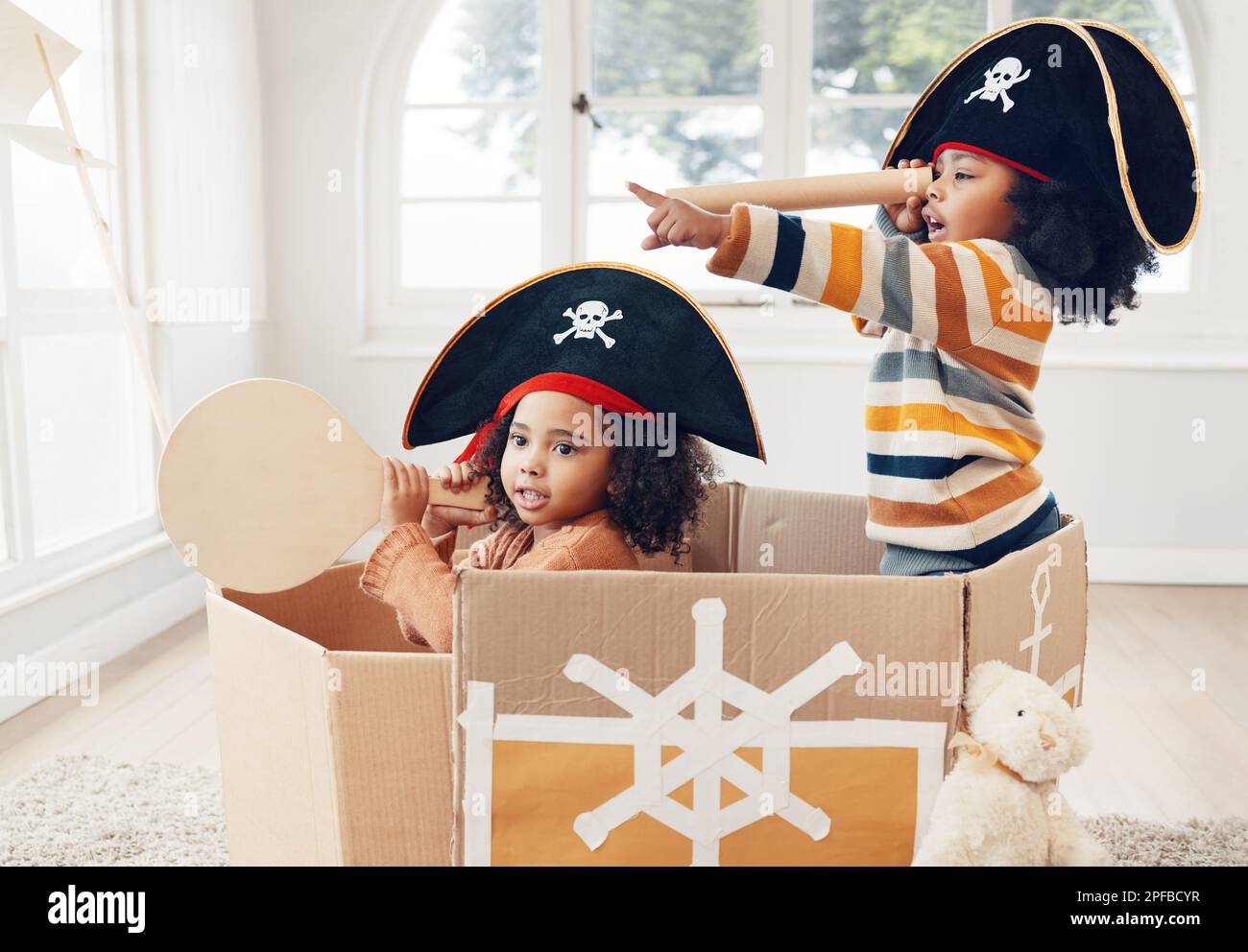 Pirate, box and telescope with children in living room for playful ...