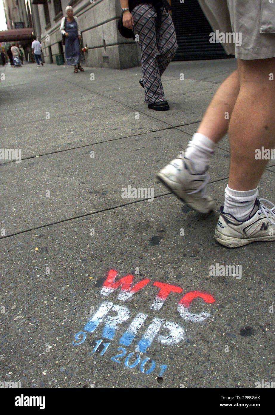 New graffiti reading "WTC, RIP, 9-11-2001" is stamped on the sidewalk ...