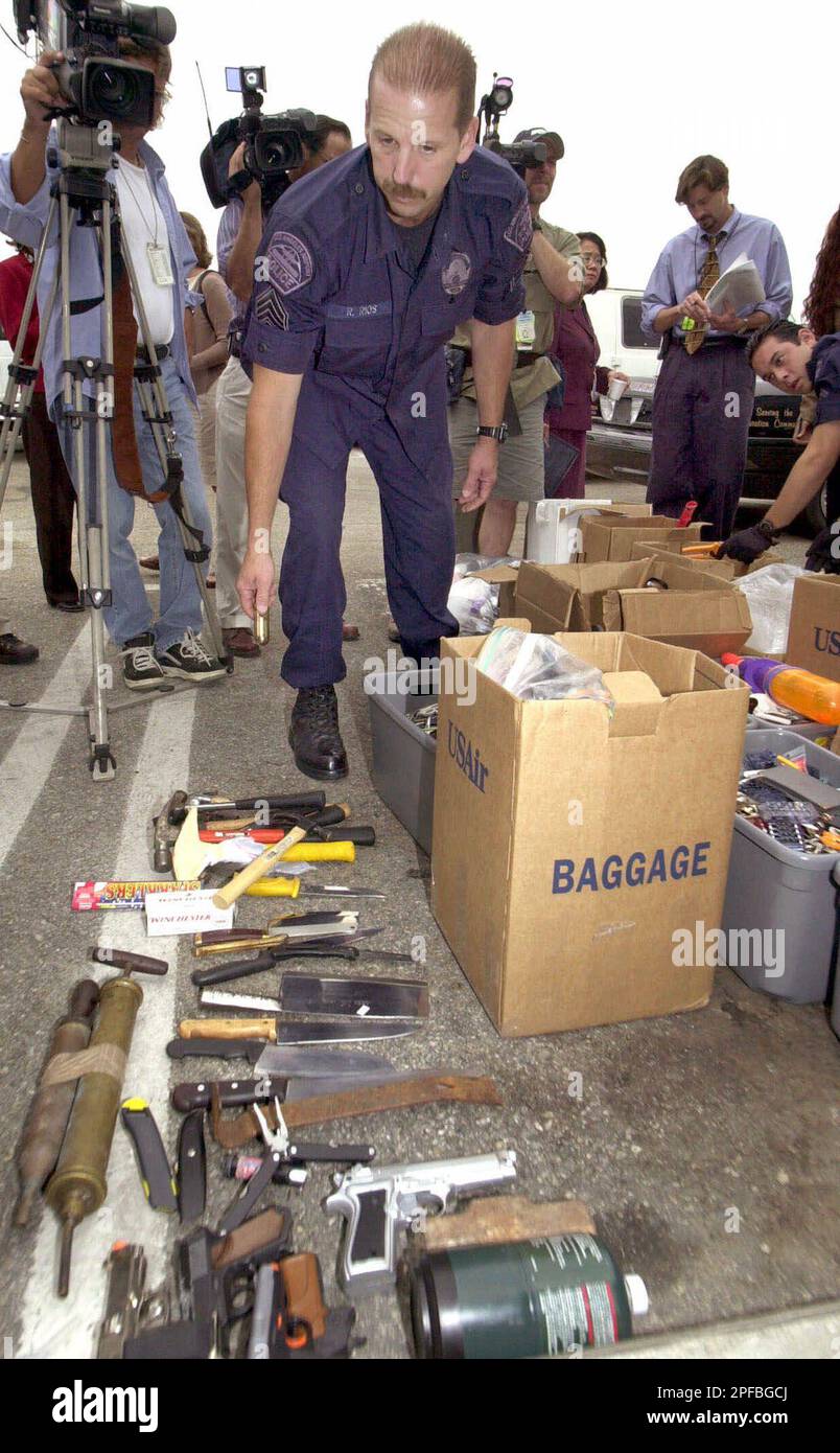 Los Angeles Officer Robert Rios displays items confiscated by airport ...