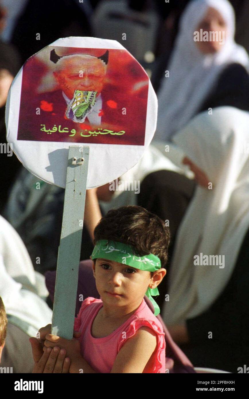 A Jordanian child carries a defaced picture of Israeli Prime Minister ...