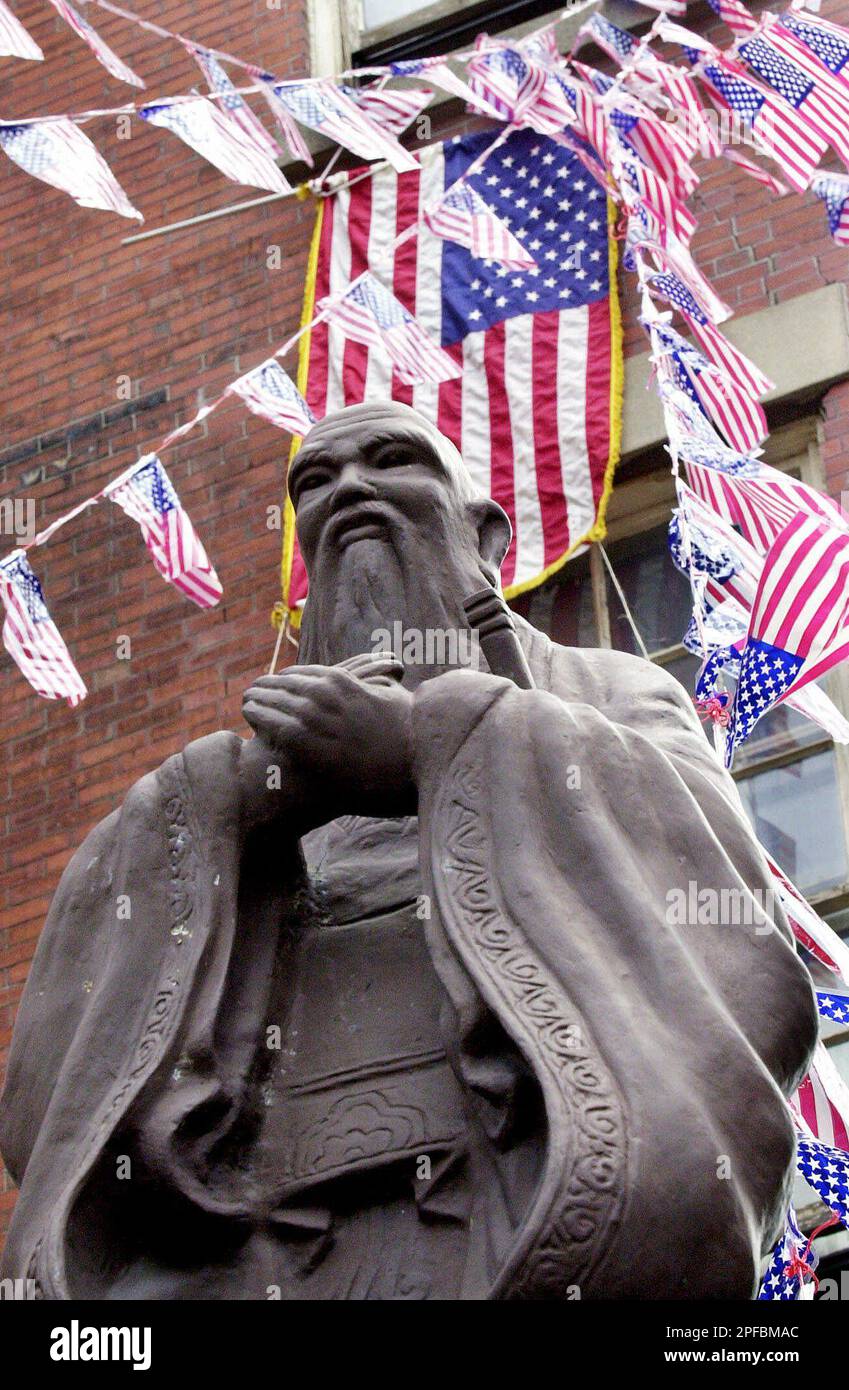 A United States flag display forms a backdrop to a statue of Chinese ...