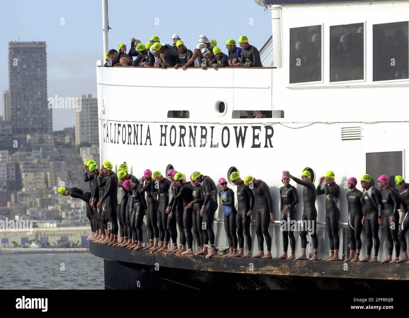 Swimmers line the edge of a ferry boat awaiting the start of the ...