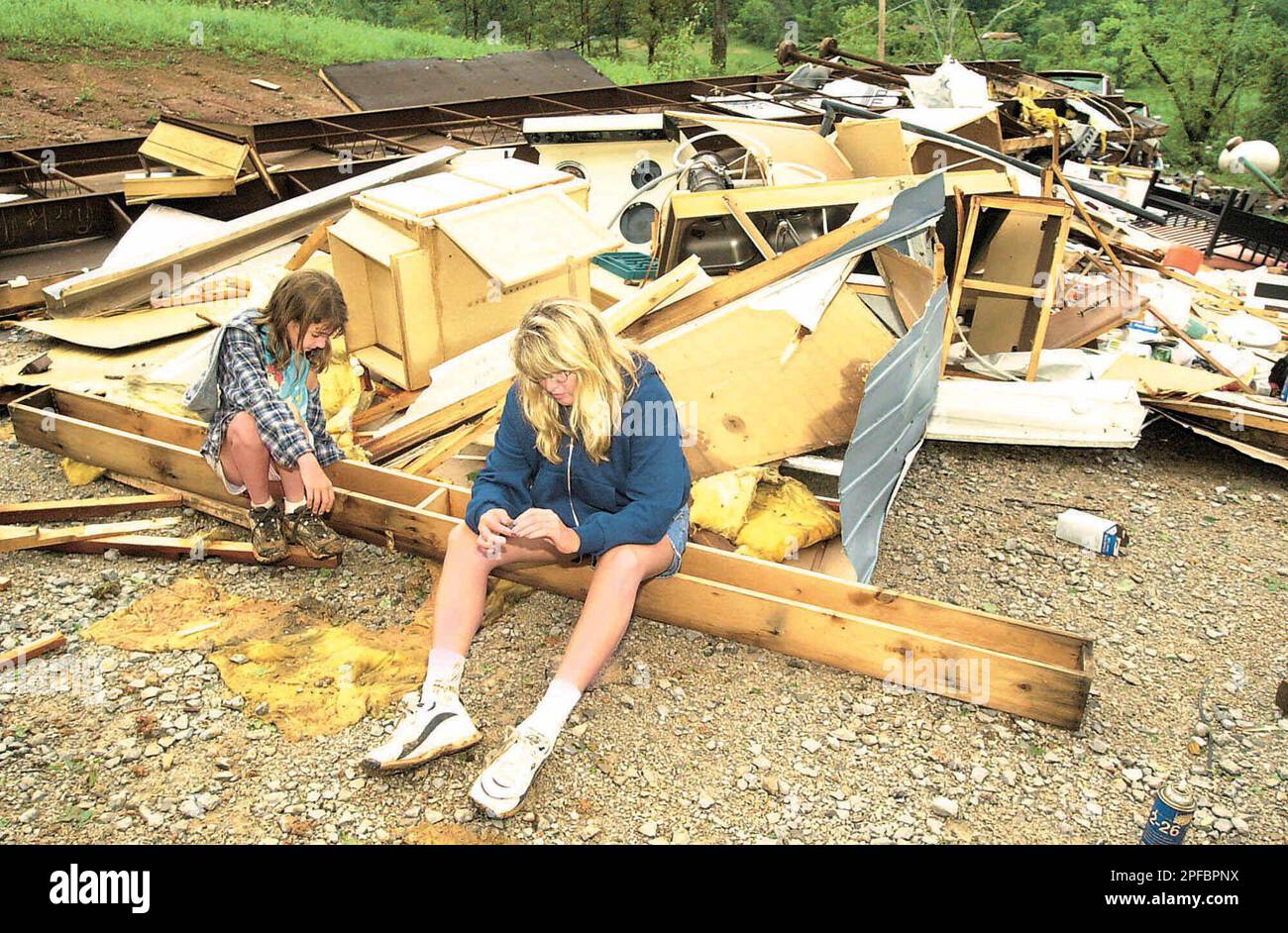 Kim Enoch with her daughter, Shelby, sit on the ruins of her fiance's ...