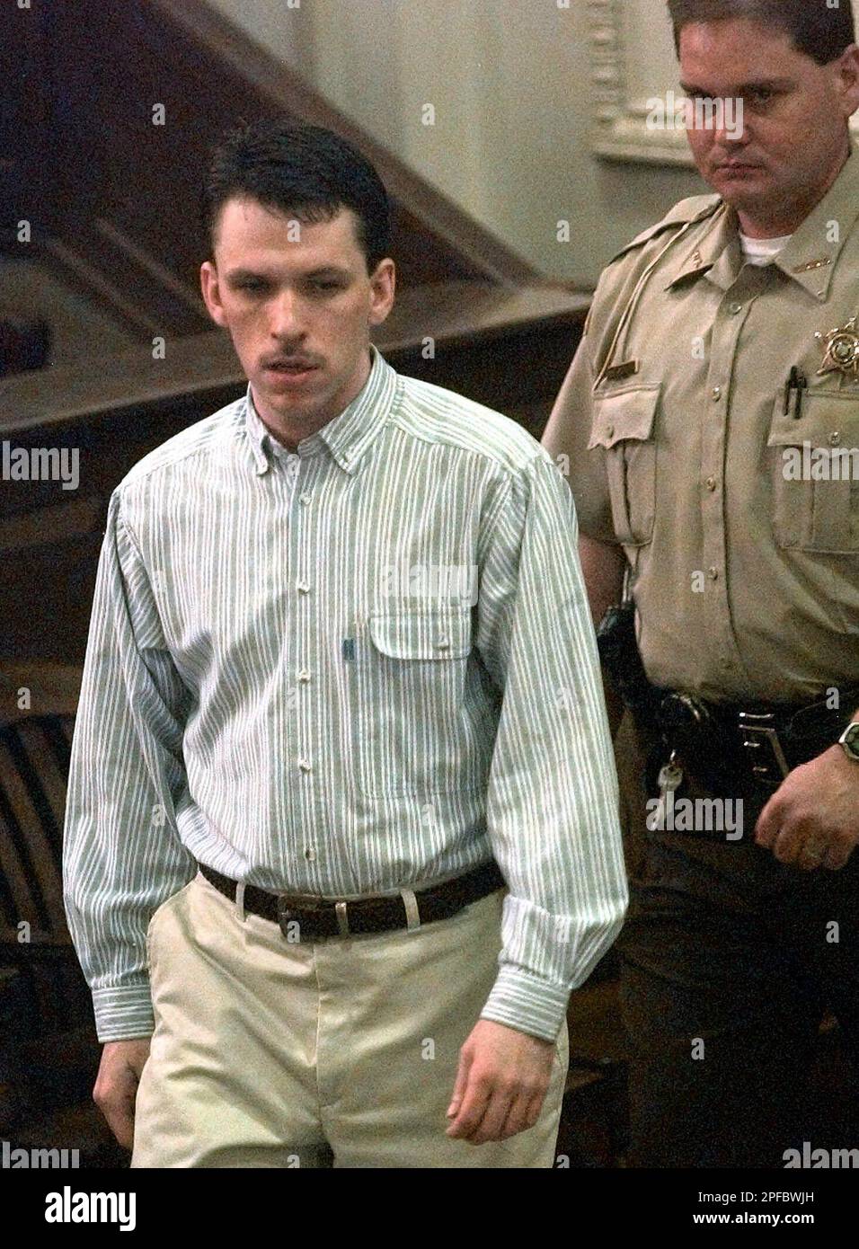 Charles Wesley Roache, left, is escorted into a Haywood County ...