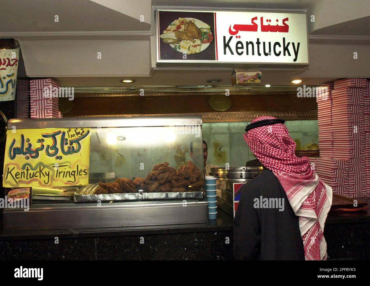 An Iraqi man waits for fried chicken at a Baghdad, Iraq fast food ...