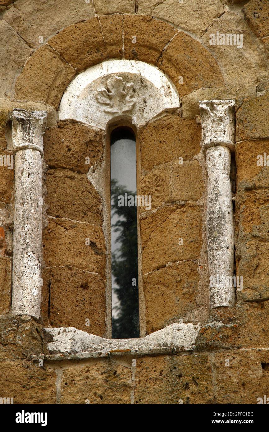 Small window with columns outside the romanesque cathedral Santi Pietro ...