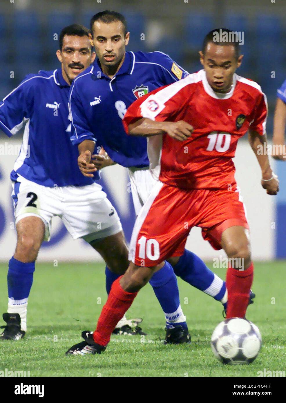 Aji Santosa of Indonesia, right, controls the ball as Osama Abdullah (2) and Saleh Alezemi (8 ...